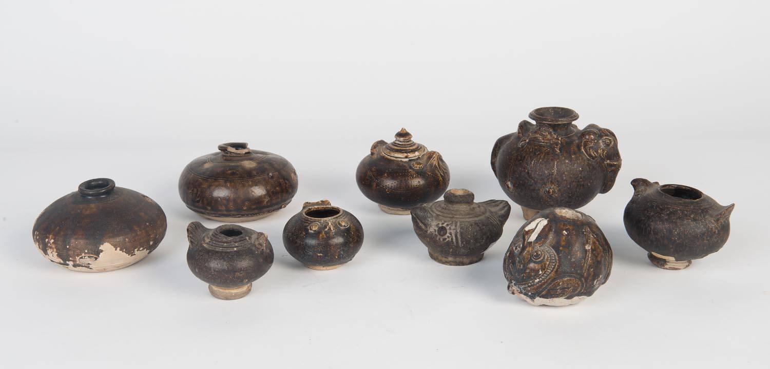 A group of nine South East Asian blak glazed jars. 4.8-10cm high ...