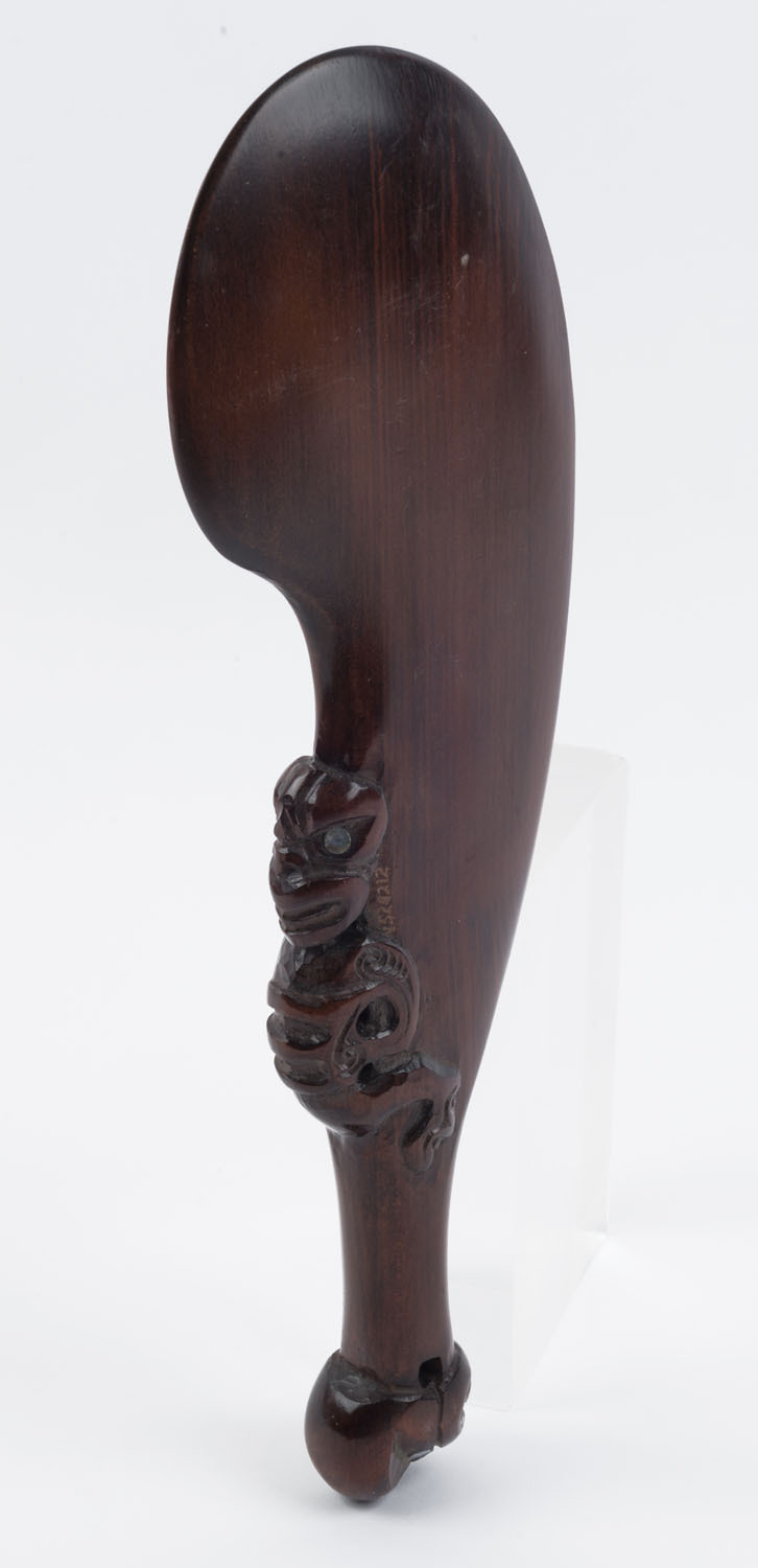 A Maori patu, carved wood and paua shell, 20th century, 40cm long