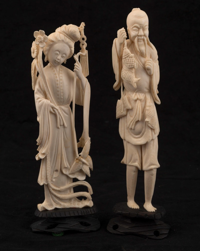 A pair of Chinese carved ivory statues of a fisherman and a lady with a ...