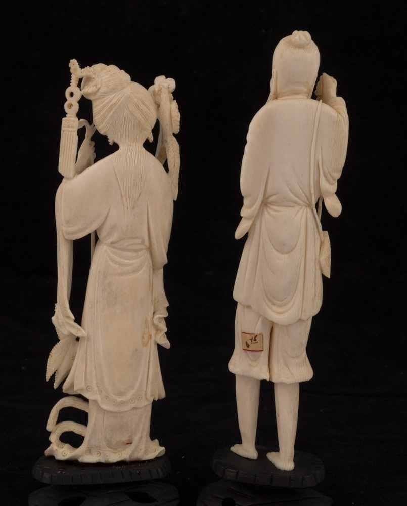 A pair of Chinese carved ivory statues of a fisherman and a lady with a ...