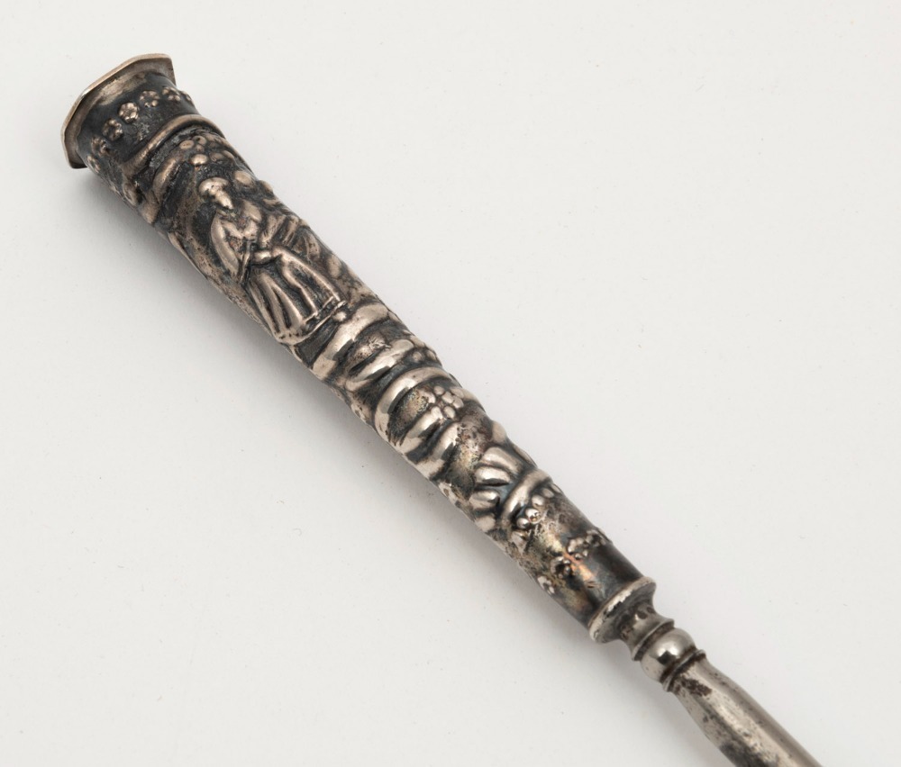 An antique silver boot hook with repousse decoration, 33.5cm long