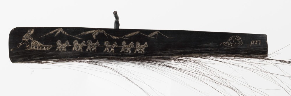 An Alaskan Inuit baleen busk with carved dogsled scene, together with a ...