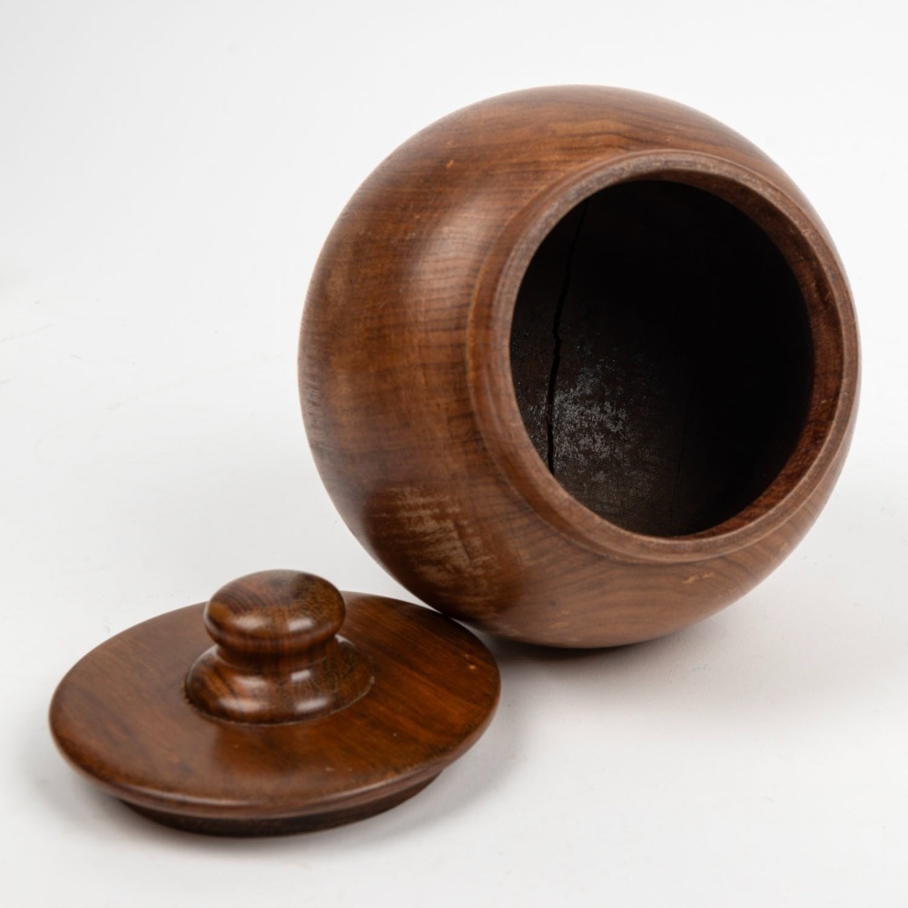 A carved blackwood lidded pot, with silver plaque affixed under the lid ...