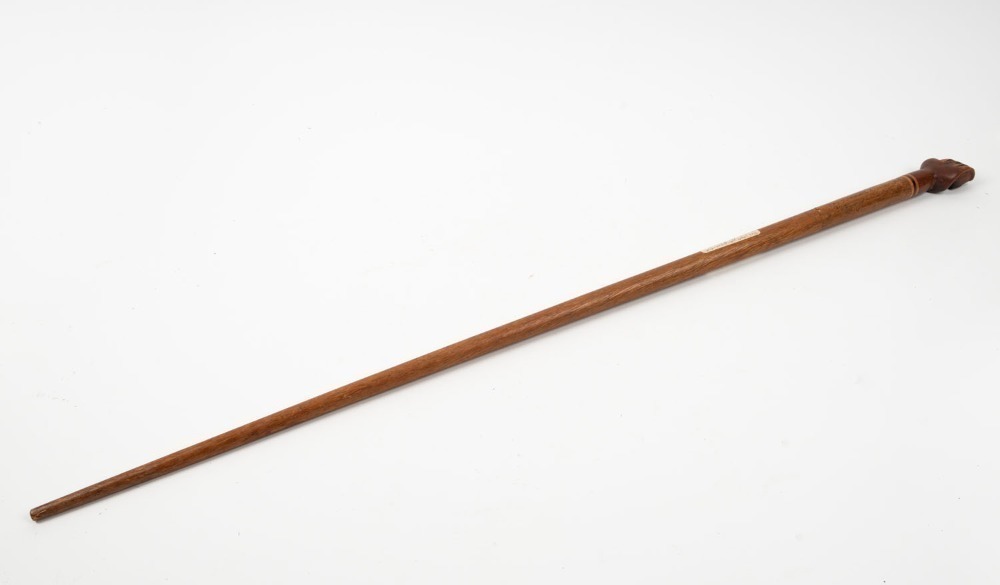 A Pitcairn Island palmwood walking stick with clenched fist handle. A ...