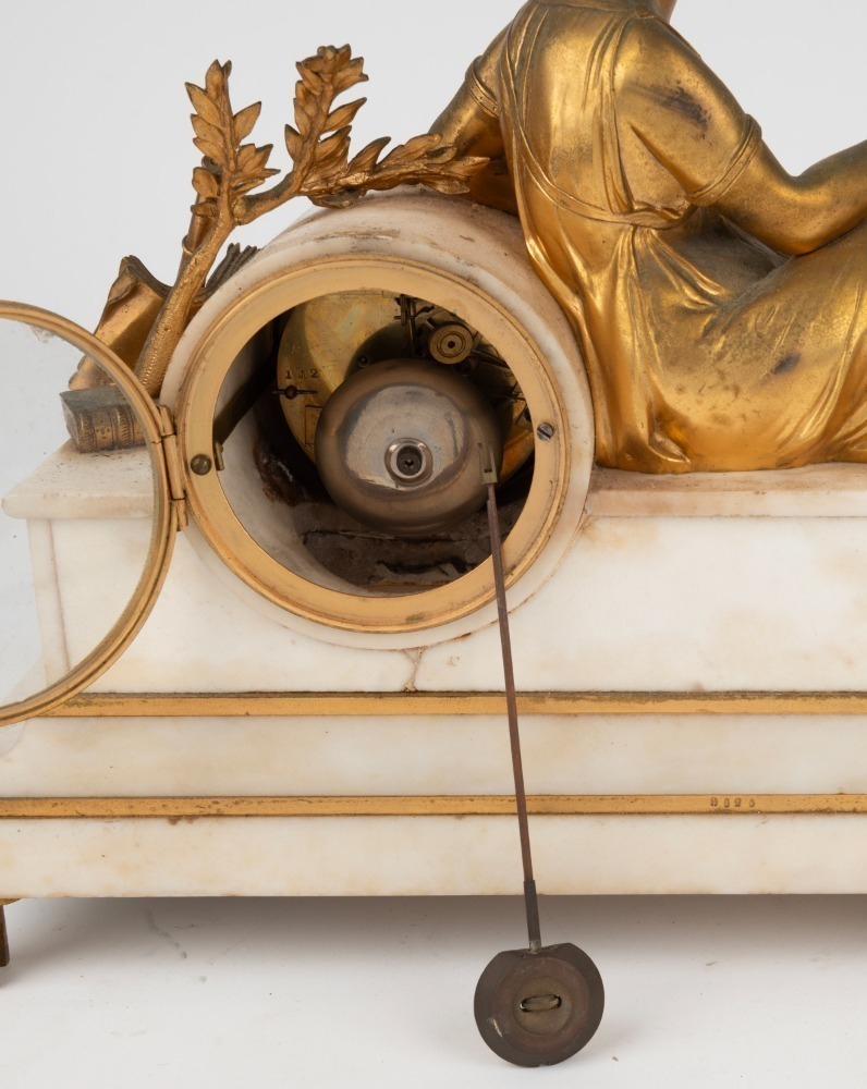 An antique French mantle clock with white marble case mounted with ...