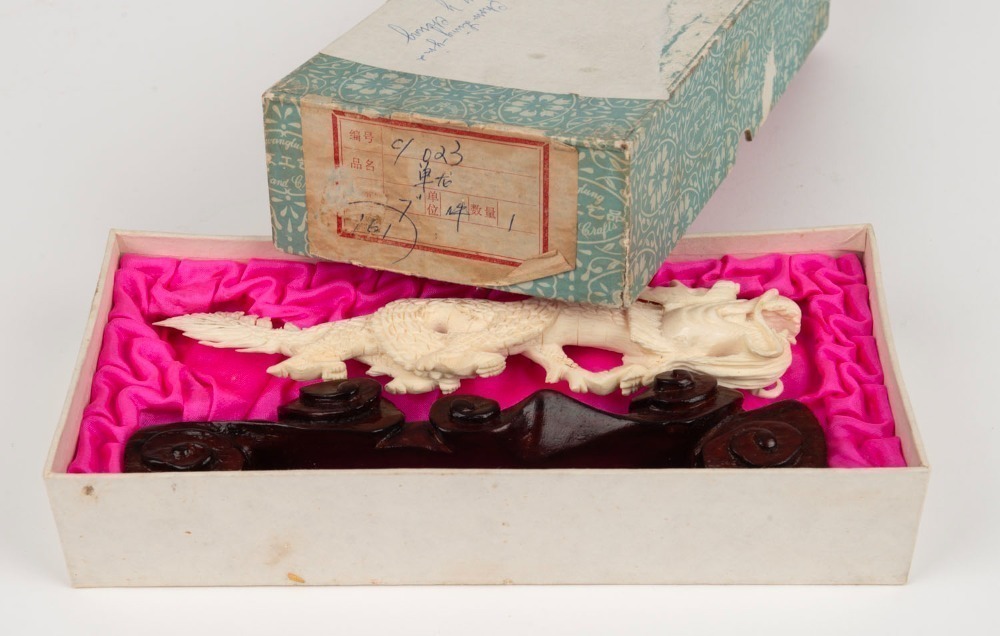 A Chinese carved ivory dragon ornament on wooden stand, early to mid ...