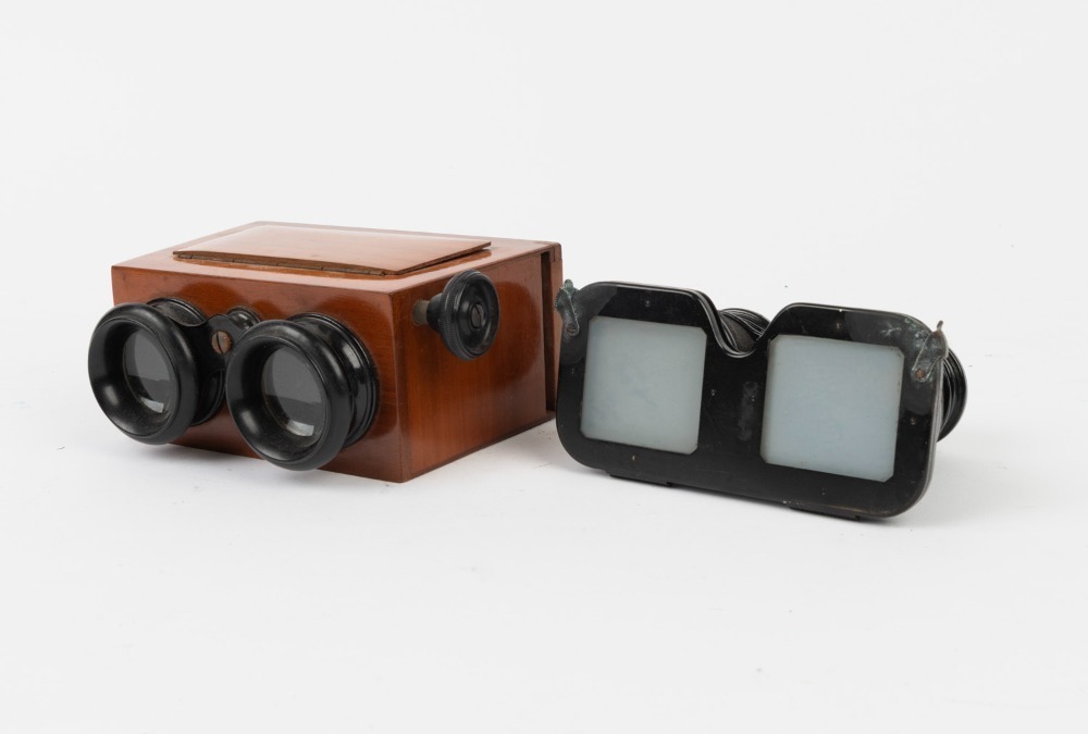 Group of four handheld stereoscopes, each of a different style ...